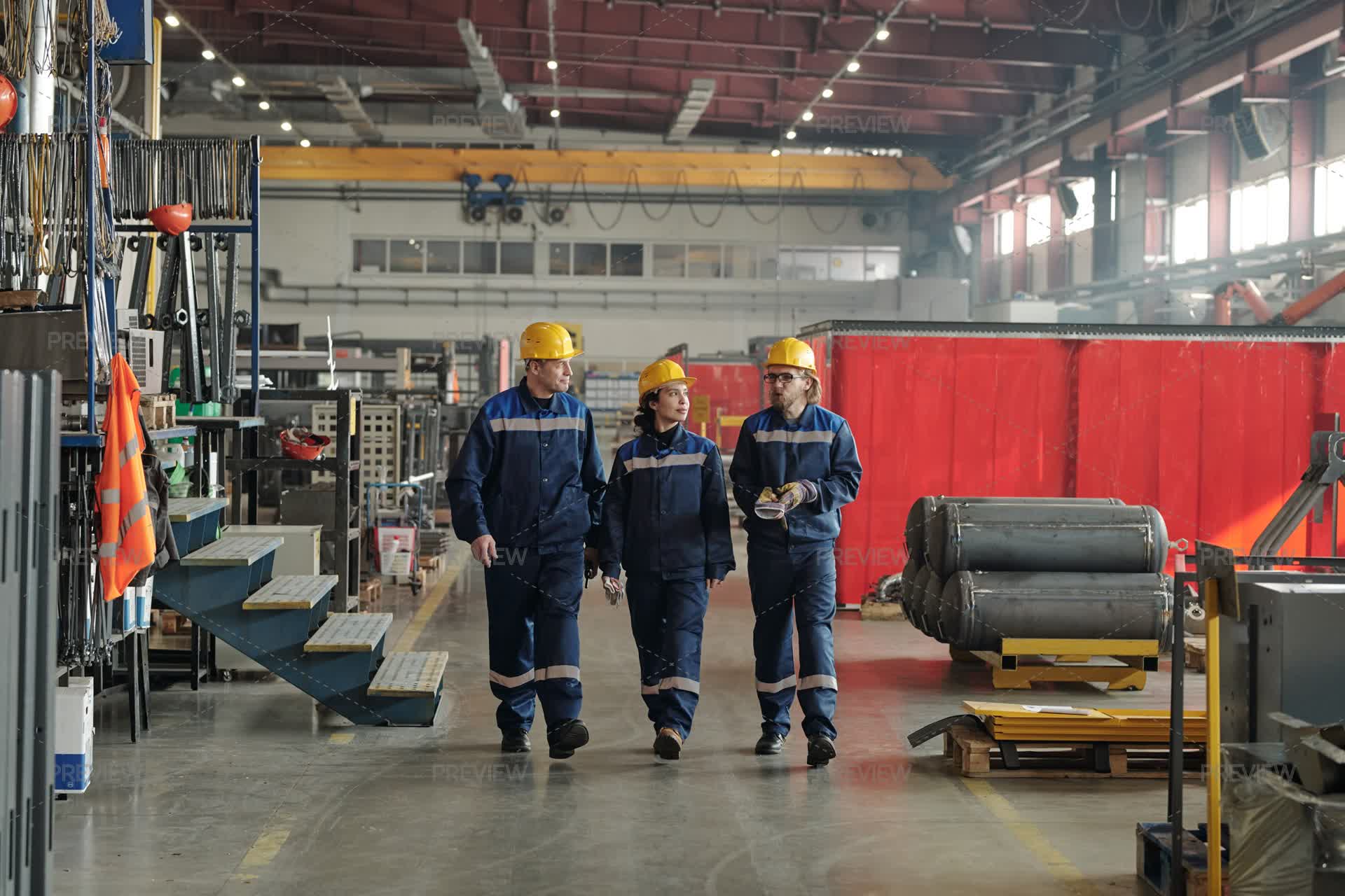Three Engineers Moving Along Workshop - Stock Photos | Motion Array Three Engineers Moving Along Workshop - Stock Photos | Motion Array