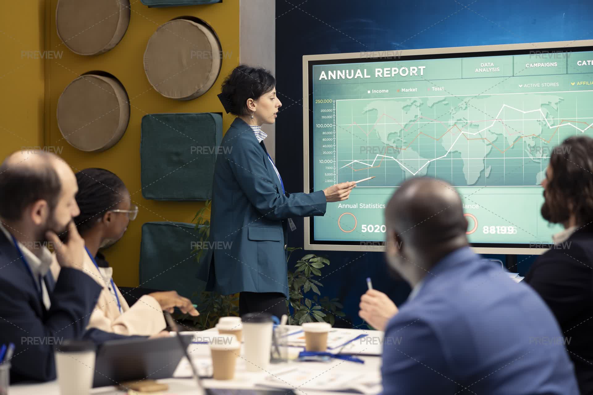 Marketing Specialist Showing Infographics In A Status Update Meeting ... Marketing Specialist Showing Infographics In A Status Update Meeting ...
